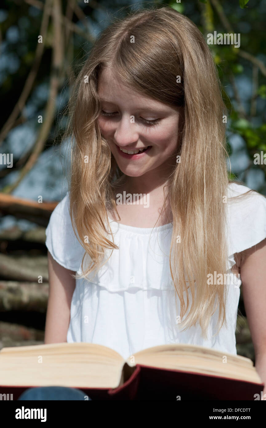 Germany, Bavaria, Girl reading book, smiling Stock Photo - Alamy