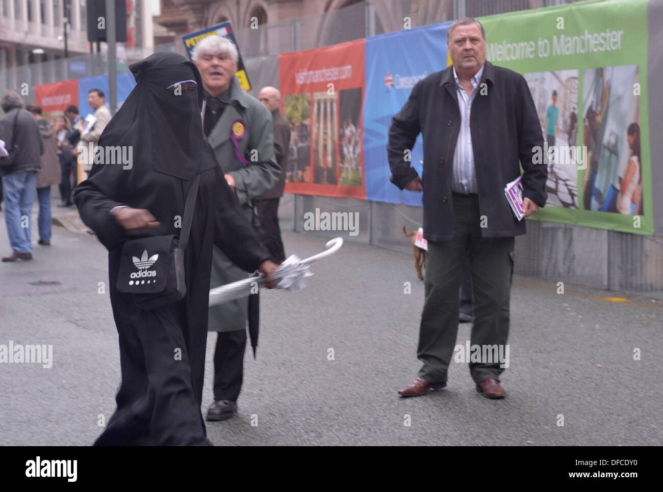 Manchester, UK. 2nd October 2013. A woman in a burka walks past Warren ...