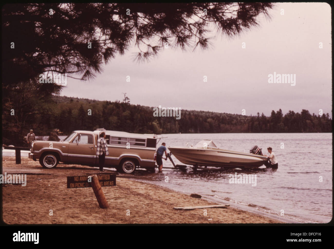 A boater uses his pickup truck camper to haul an outboard motor ...