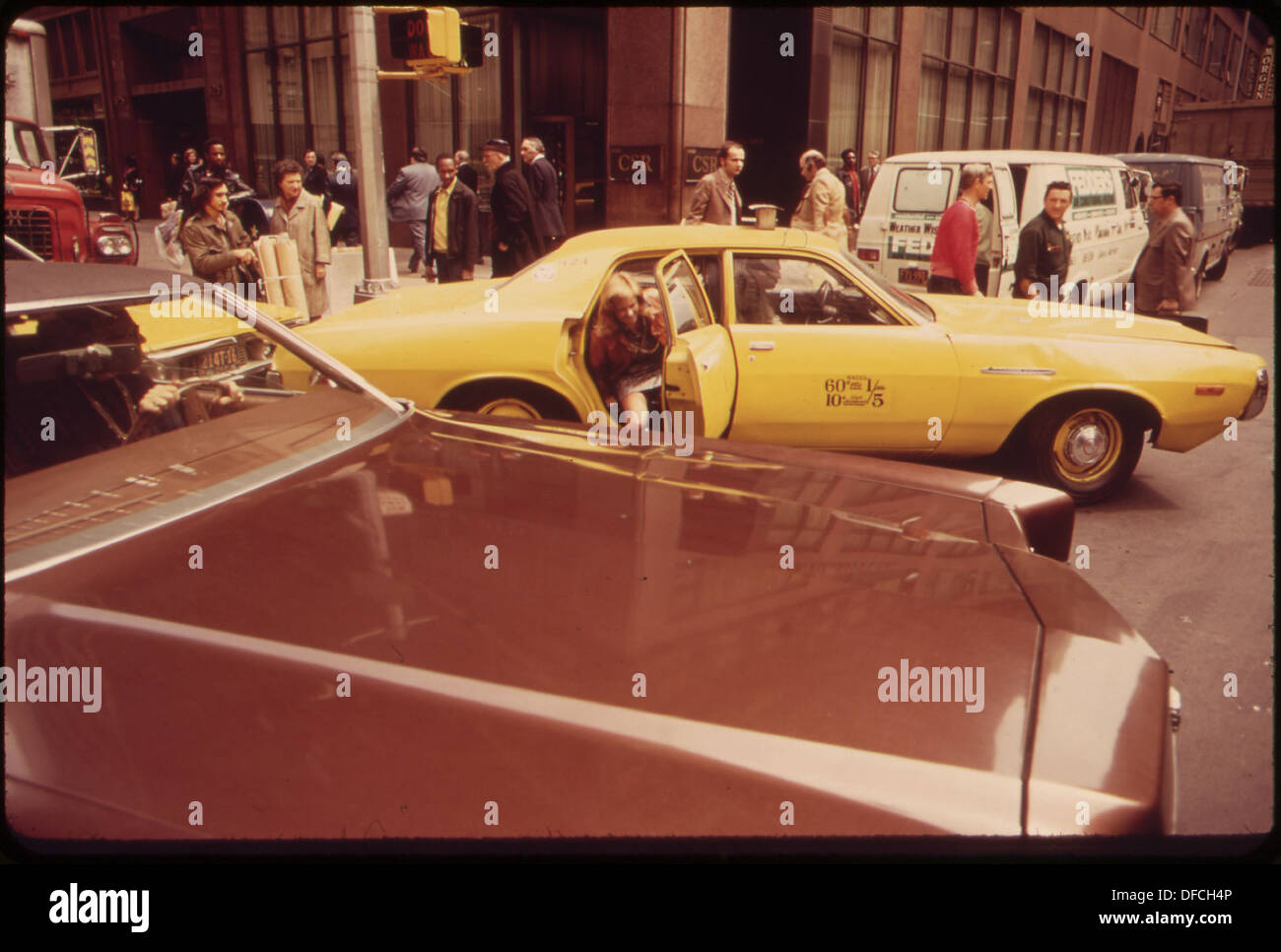 A taxi cab blocks traffic in a busy midcity street as a passenger ...