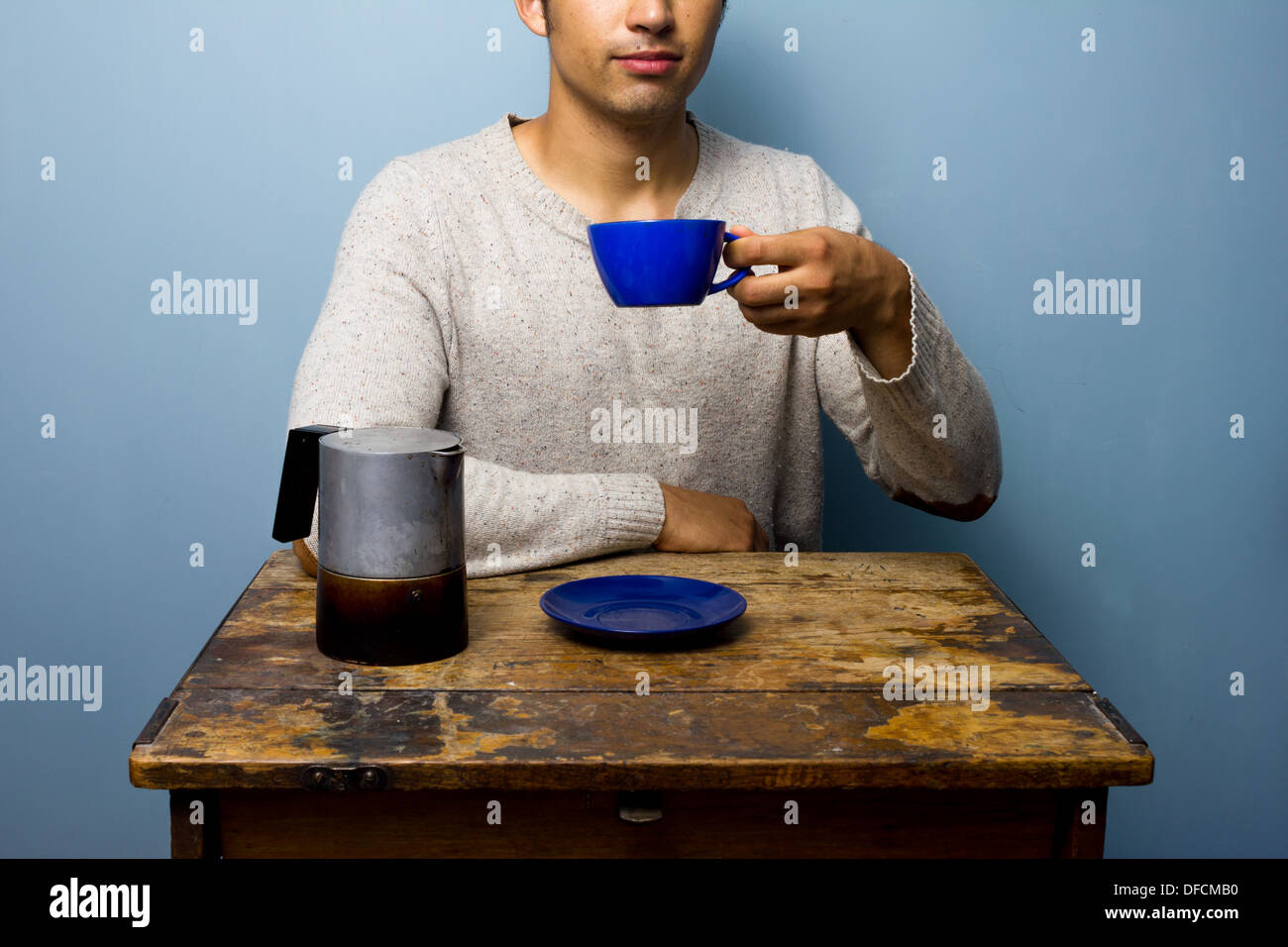 Young man seated table hi-res stock photography and images - Alamy