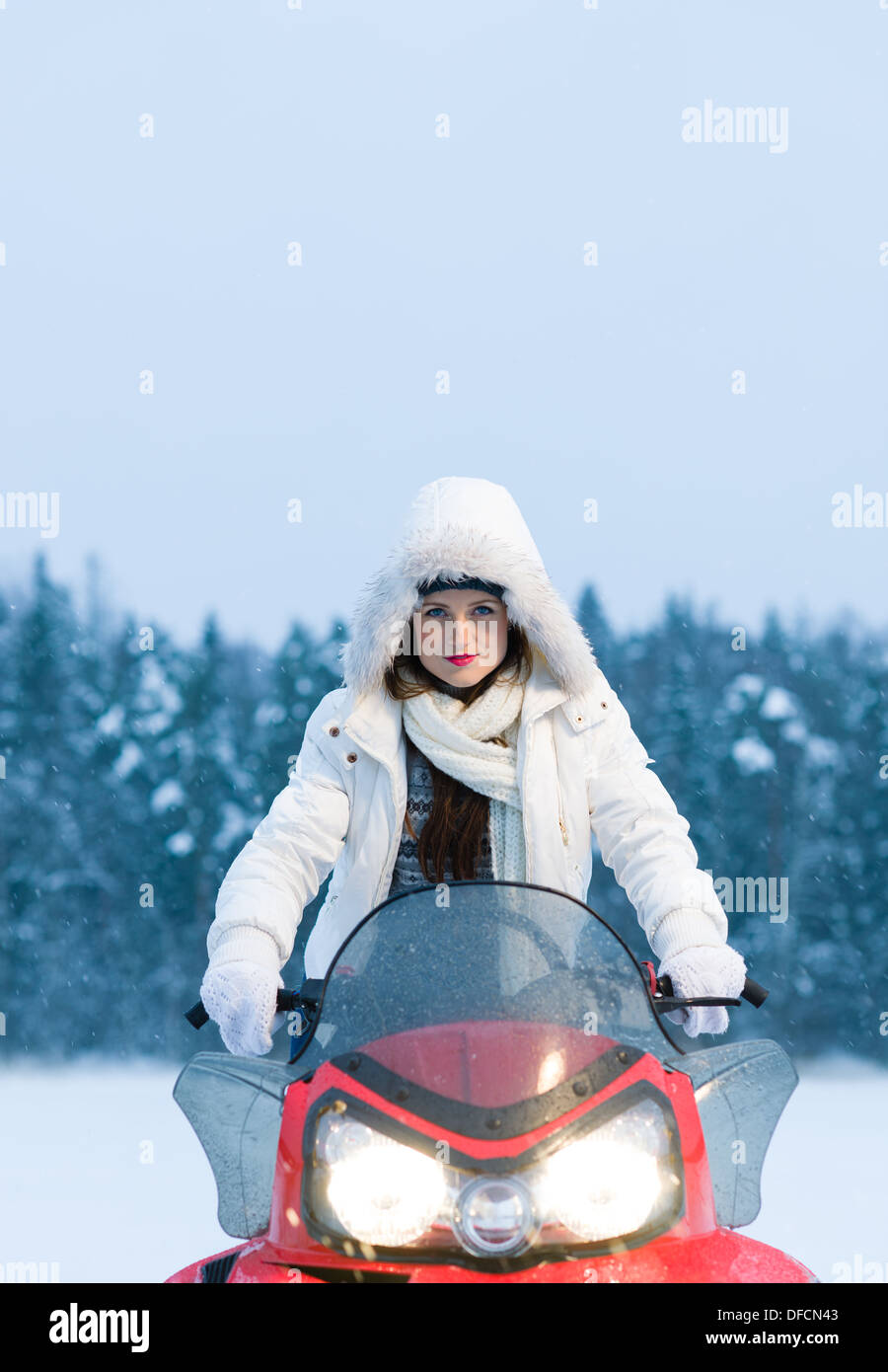 Winter, beautiful woman and a snowmobile, vertical format Stock Photo ...