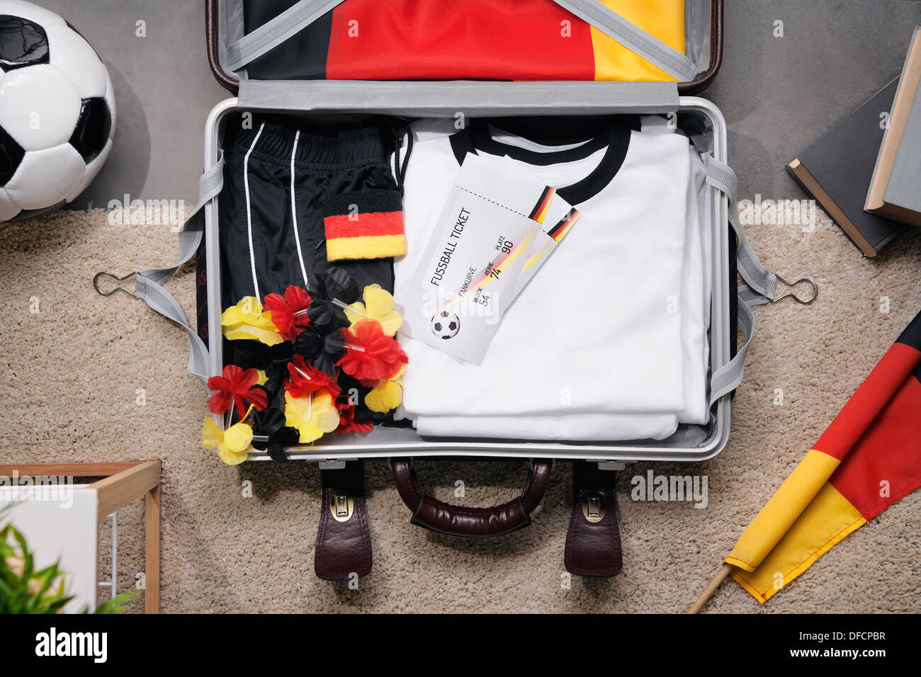 Football shirt , tickets and fan articles packed in suit case, studio ...