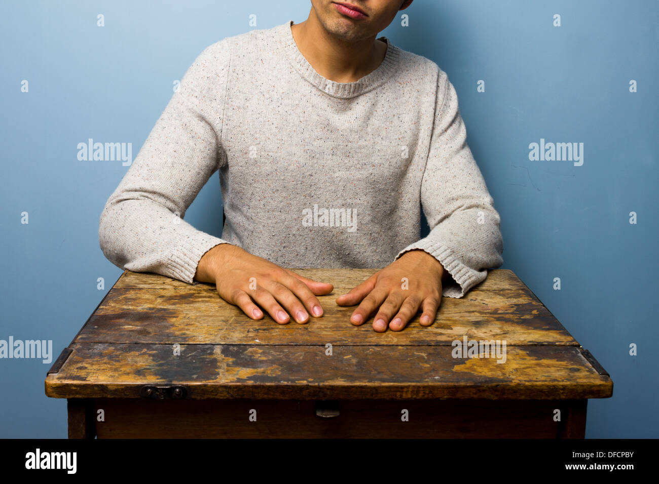 Young man is sitting at desk Stock Photo - Alamy