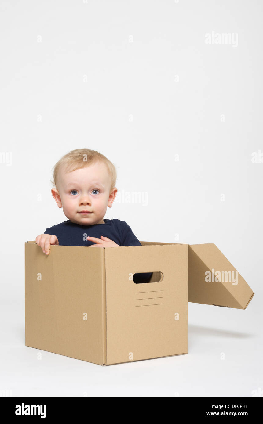 Portrait of baby boy sitting in box on white background Stock Photo - Alamy