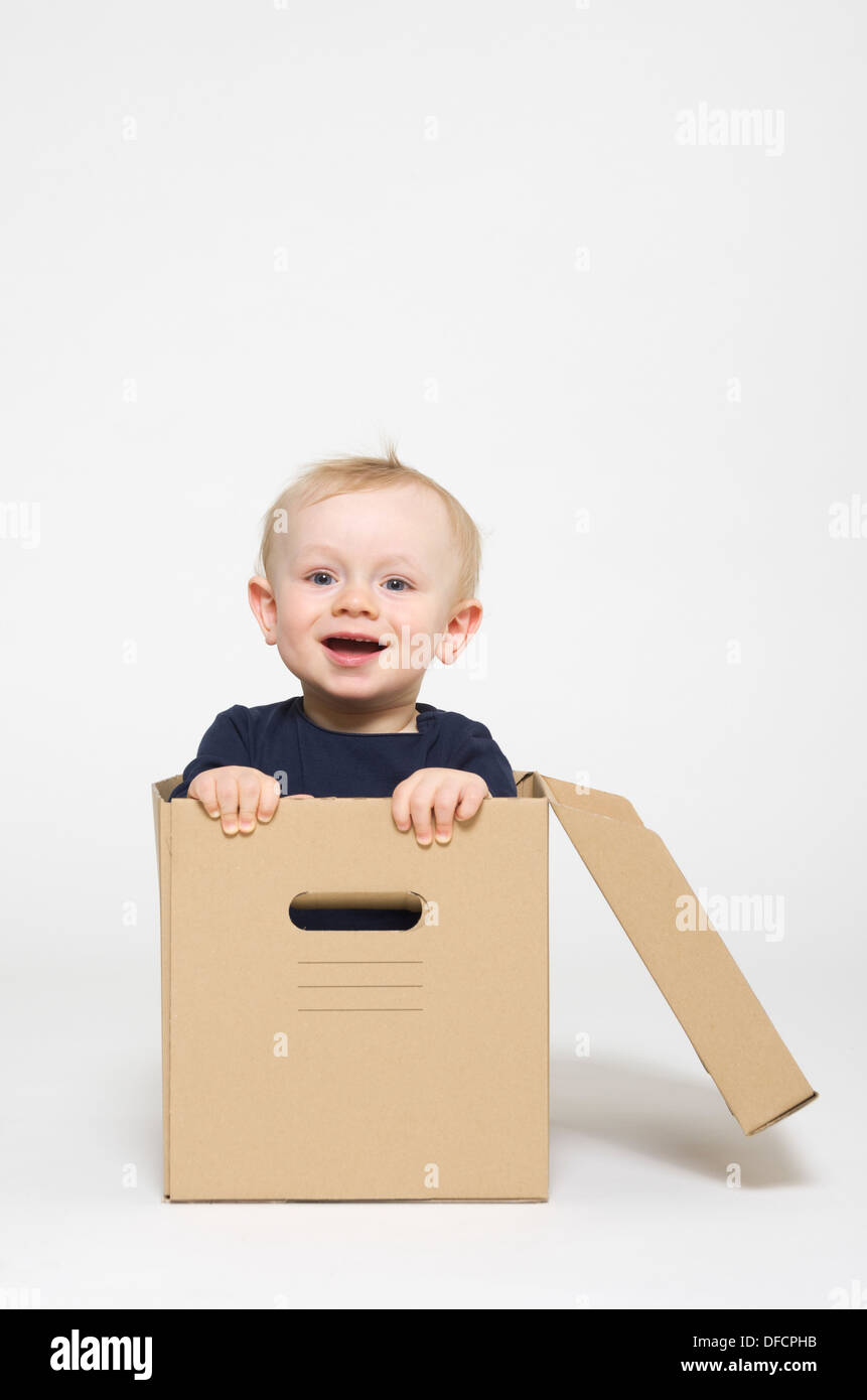 Portrait of baby boy sitting in box, smiling Stock Photo - Alamy