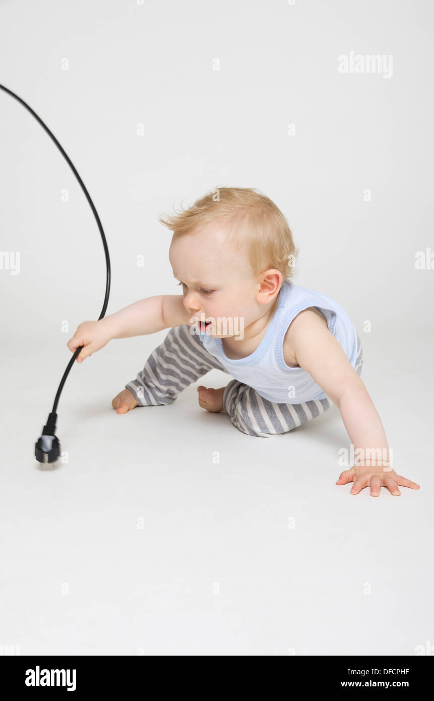 Baby boy playing with cable wire Stock Photo - Alamy