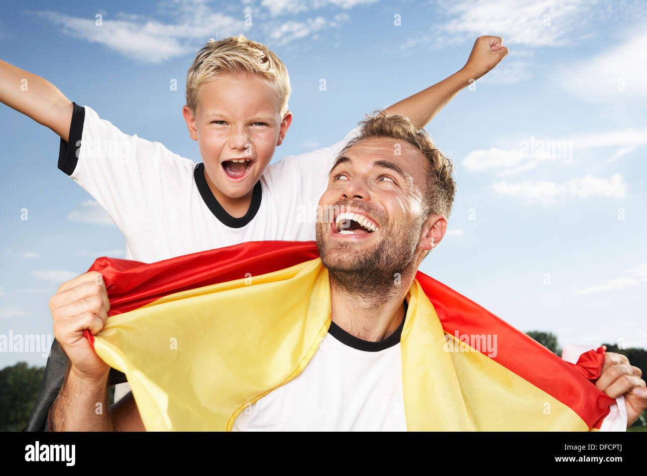 Germany, Cologne, Father and son cheering in football outfit Stock ...