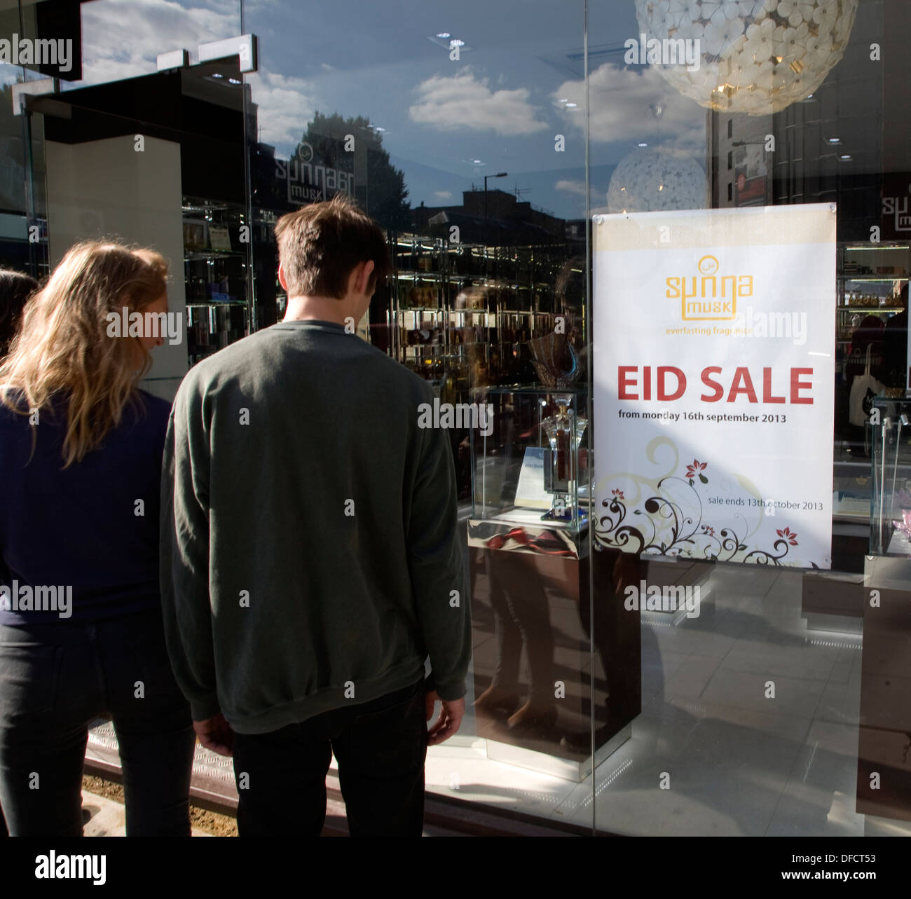 Two young adults look at shop window advertising Eid sale, Whitechapel ...