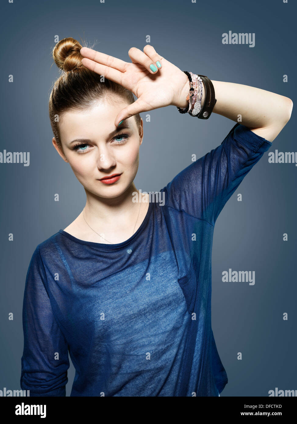 Teenage girl doing loser hand sign Stock Photo - Alamy