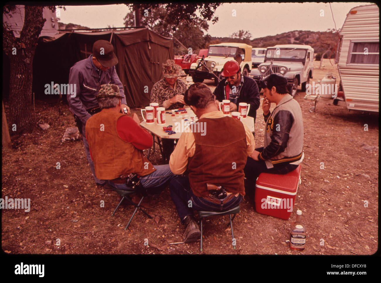 This image depicts deer hunters drinking and playing poker while ...