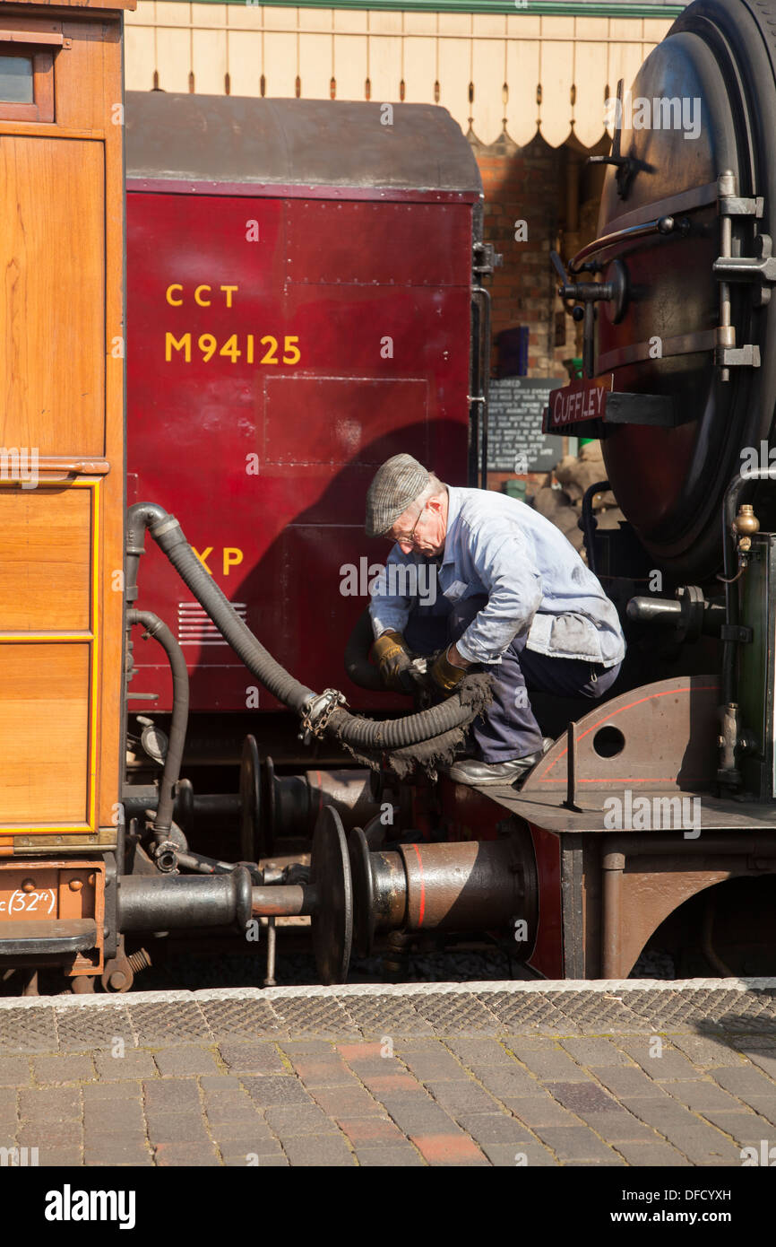 Engineer coupling a carriage at Sheringham 1940's weekend festival ...