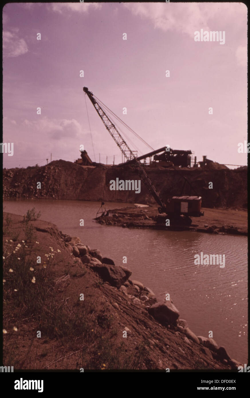 A dragline machine is shown dredging material for blacktopping near ...