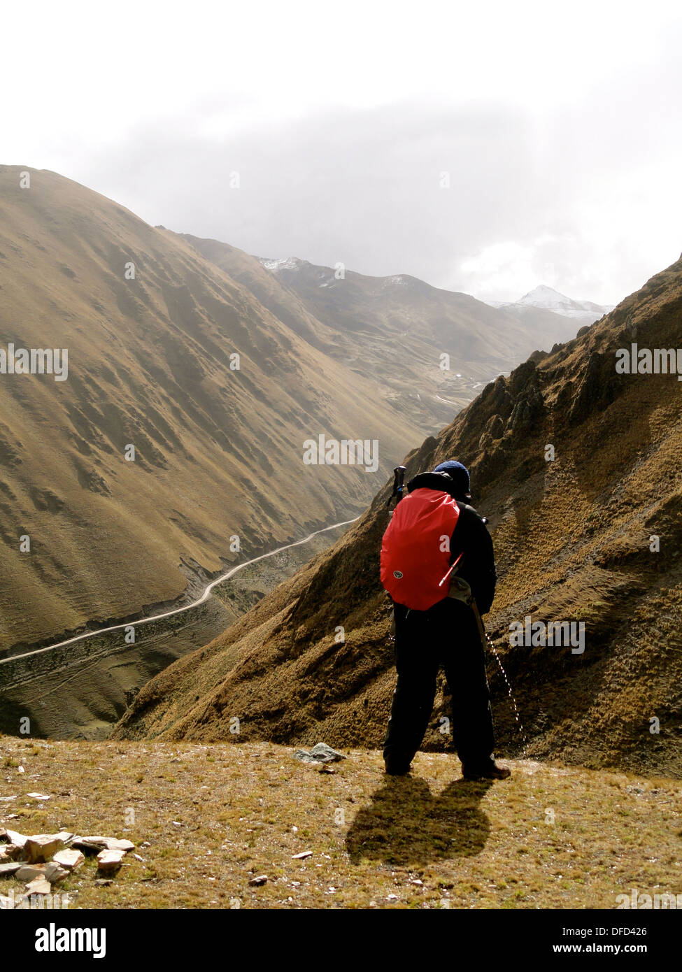 A man peeing while out walking in the Andes mountains during a trek in the Lares Valley, near ...