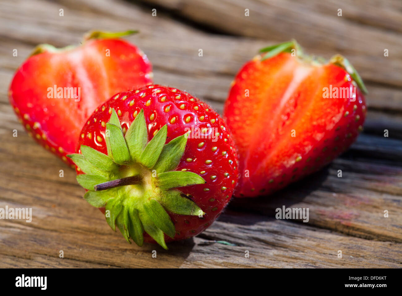 One whole and one halved strawberry hi-res stock photography and images ...