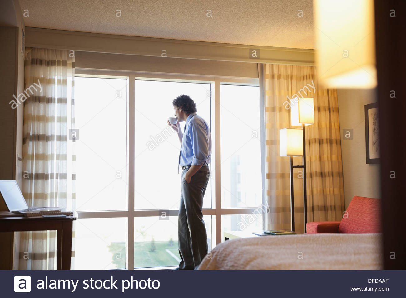 Businessman looking out hotel window hi-res stock photography and ...