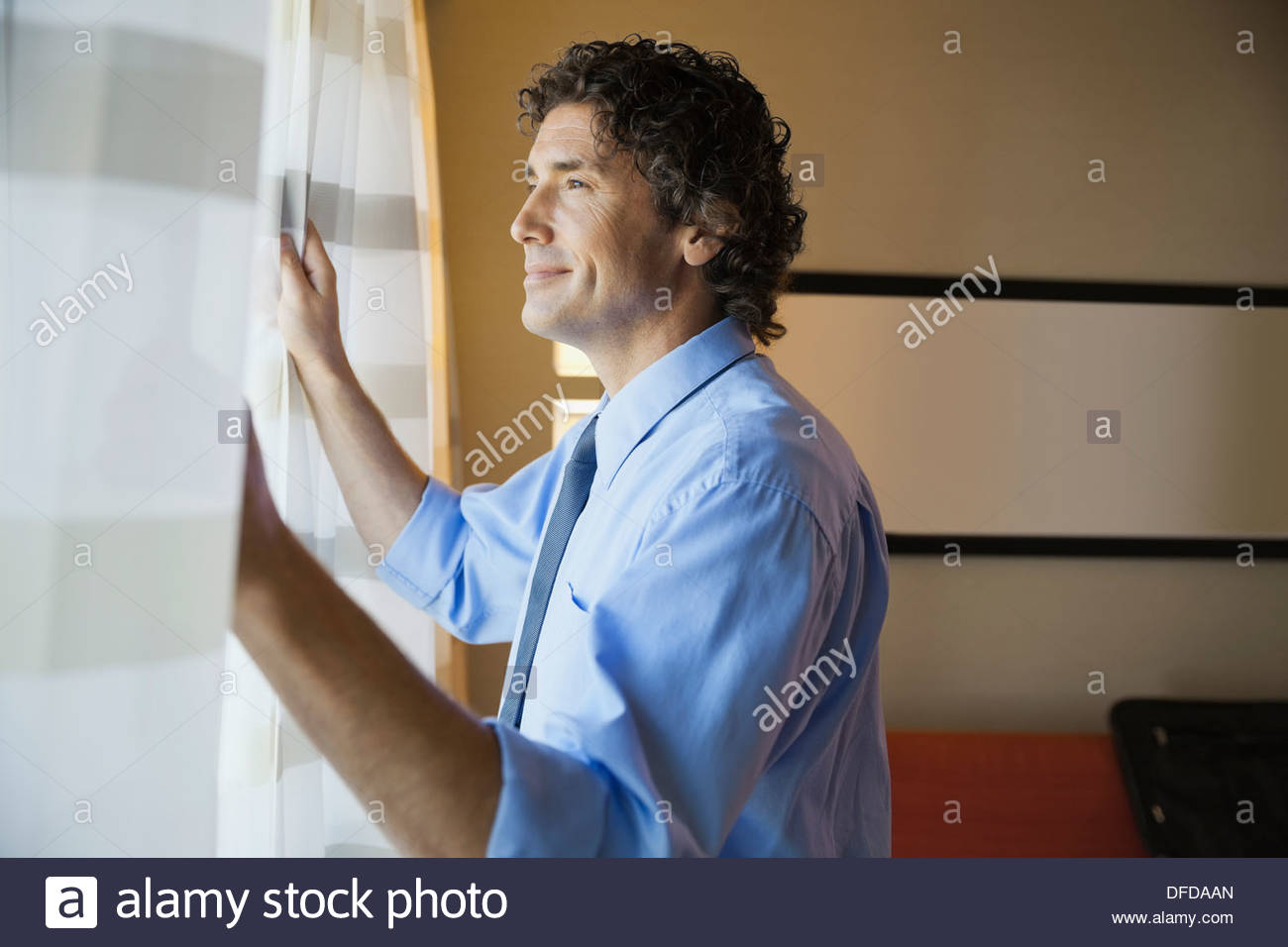 Businessman looking out hotel window hi-res stock photography and ...