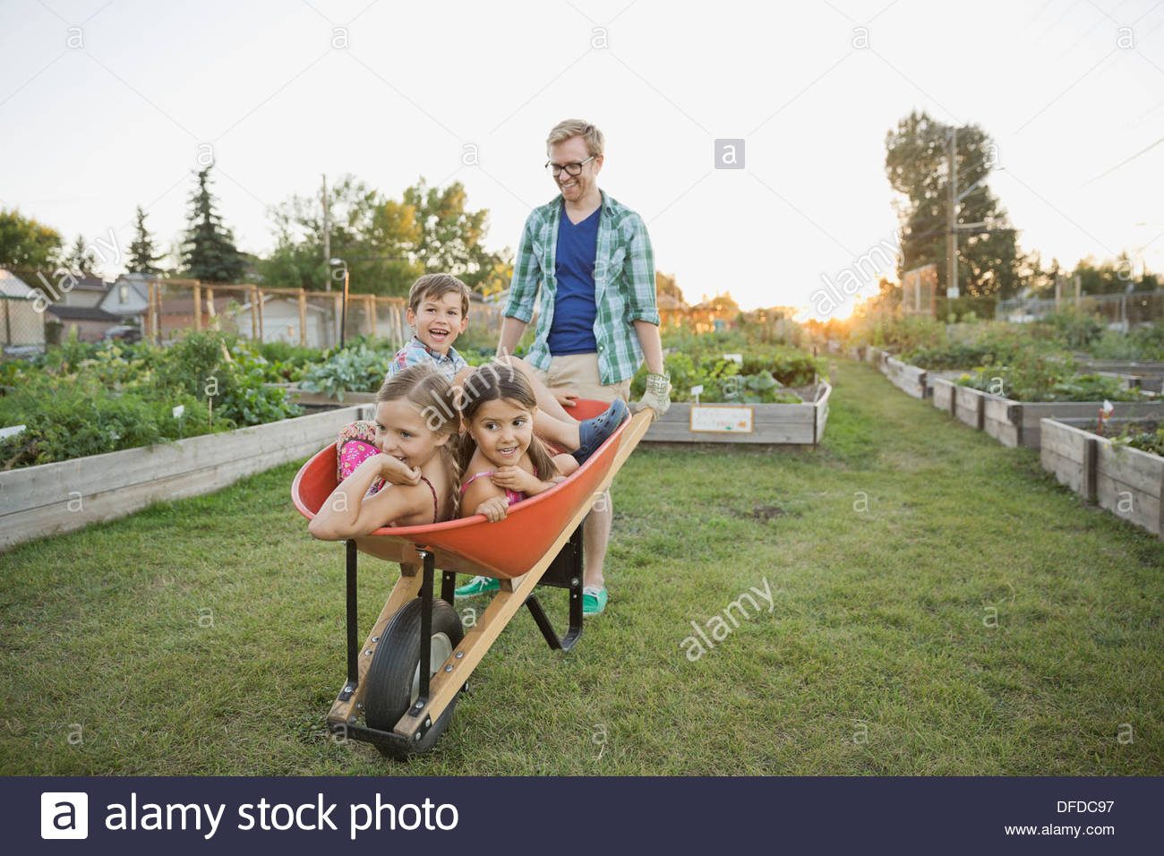 Kids pushing wheelbarrow hi-res stock photography and images - Alamy