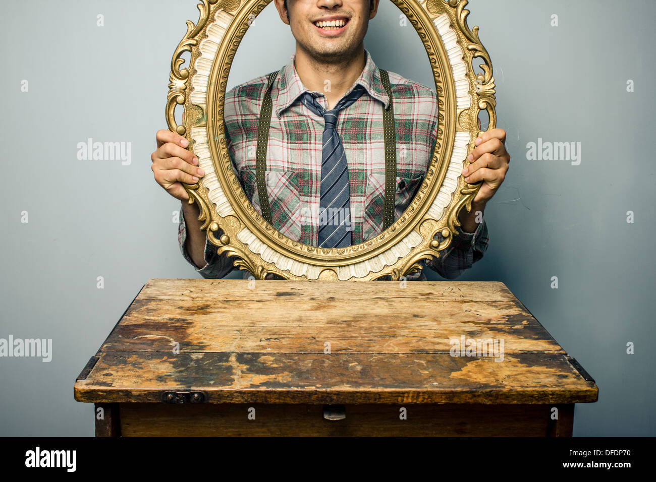 Young man looking through an empty picture frame Stock Photo - Alamy