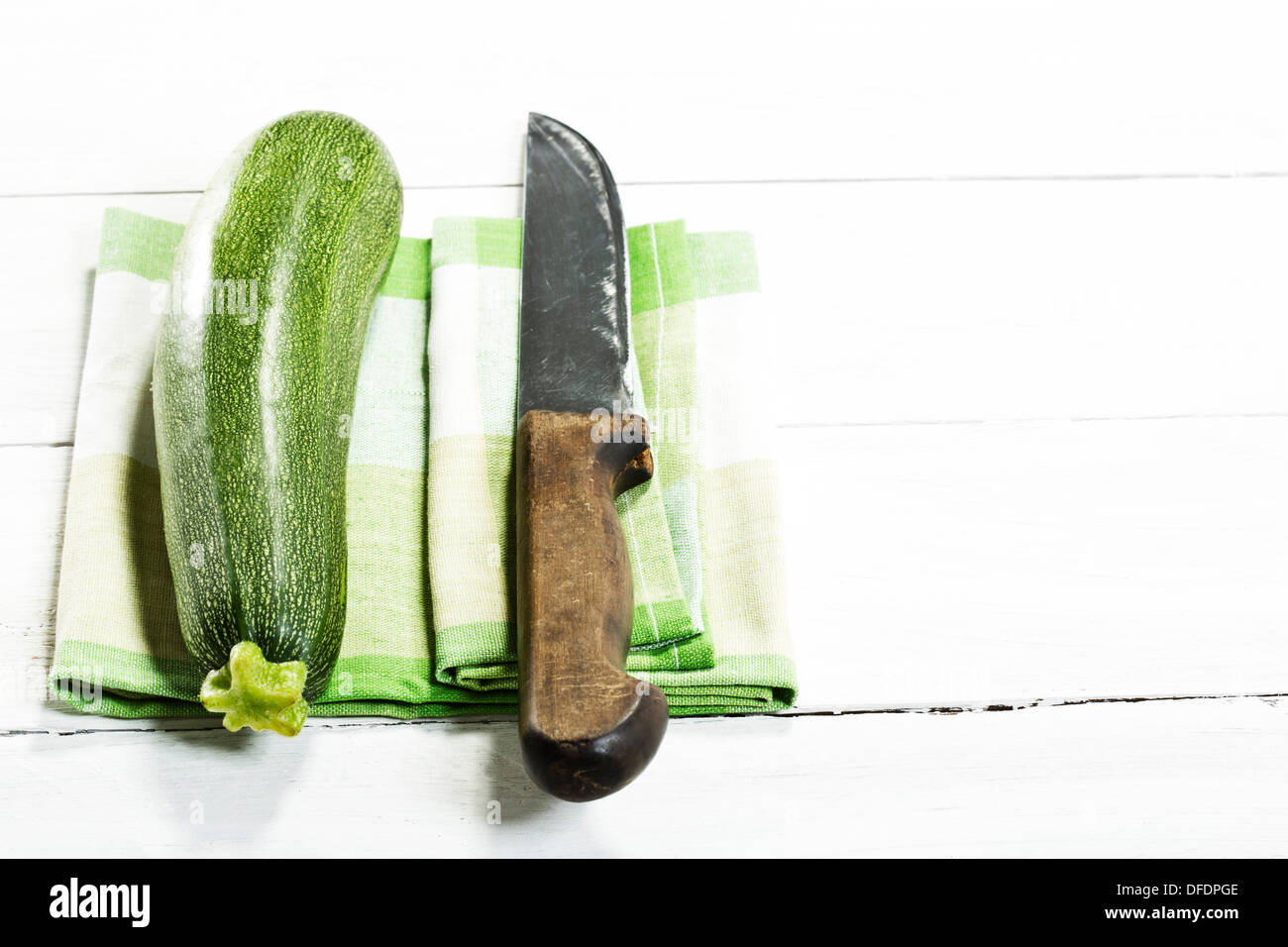 Zucchini with napkin and knife on wooden table, close up Stock Photo ...