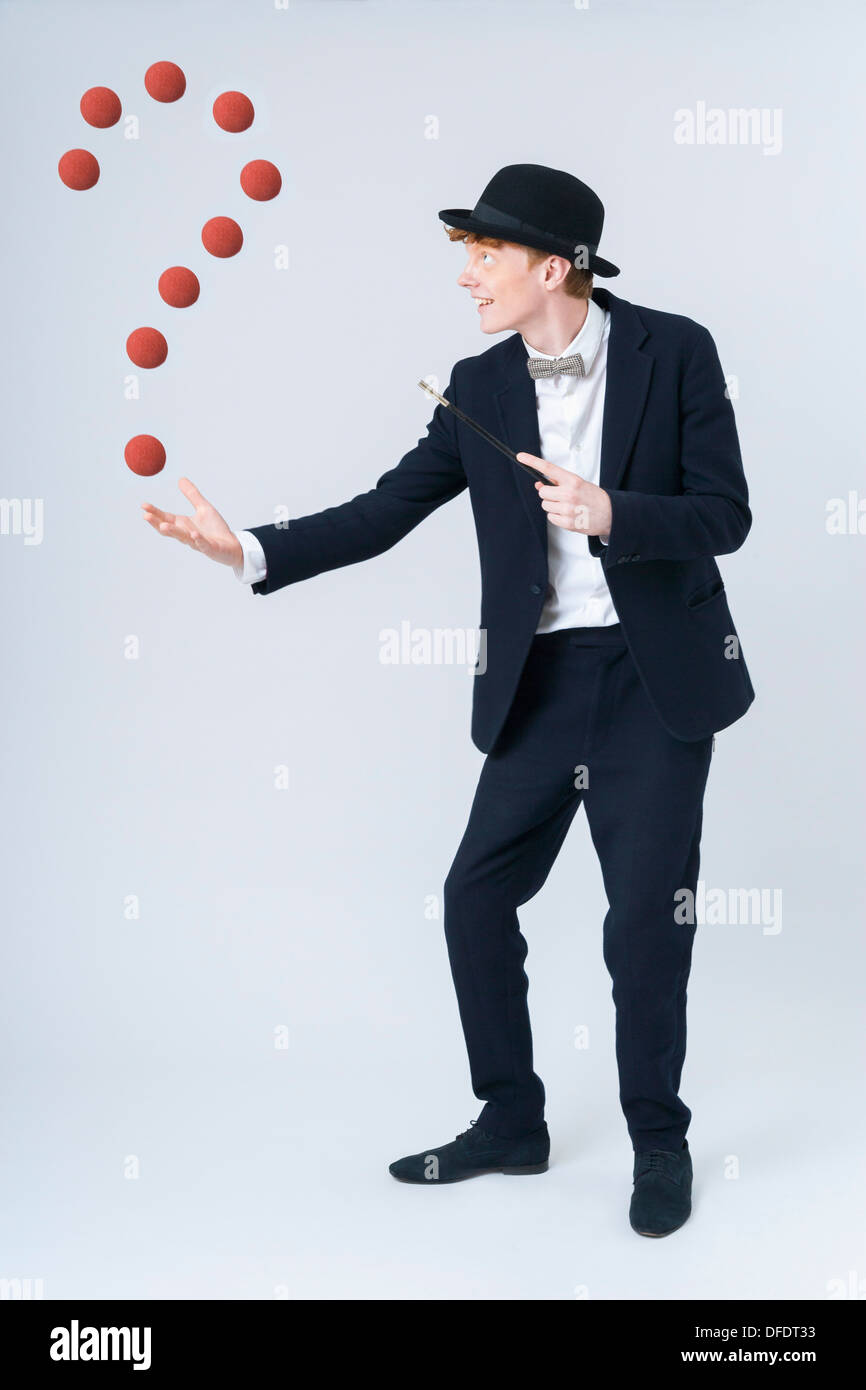Young man showing magic with ball, smiling Stock Photo - Alamy