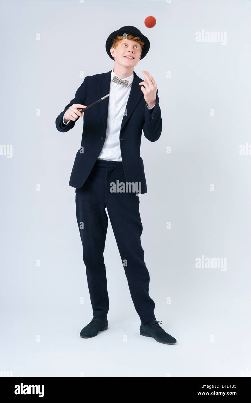 Young man showing magic with ball, smiling Stock Photo - Alamy