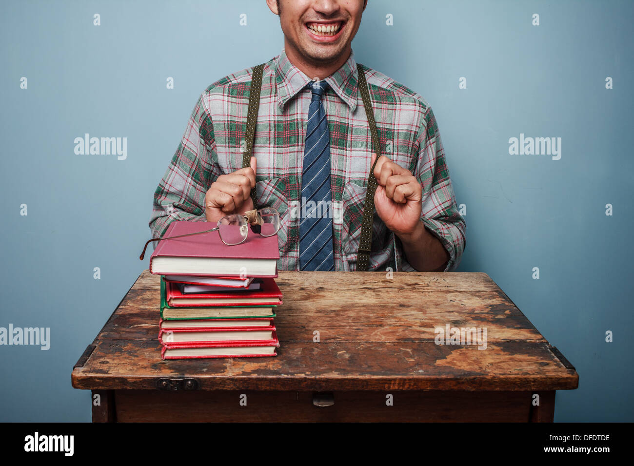 Young nerd sitting at an old school desk with a stack of books Stock ...