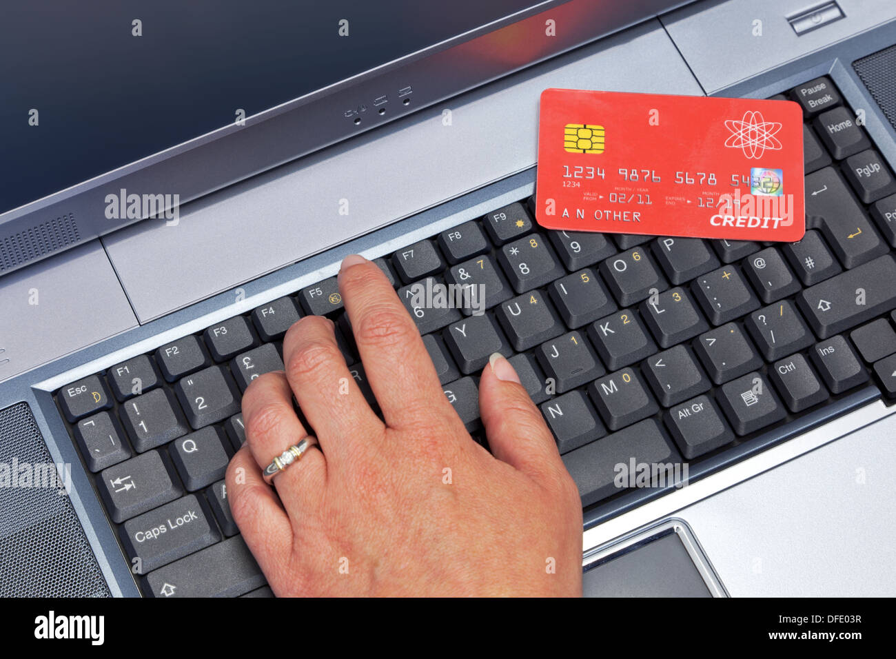 A woman typing in her credit card details on a laptop computer. The ...