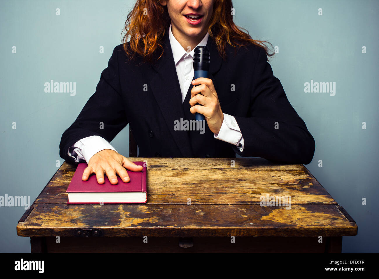 Young business woman is talking into microphone and giving a seminar ...