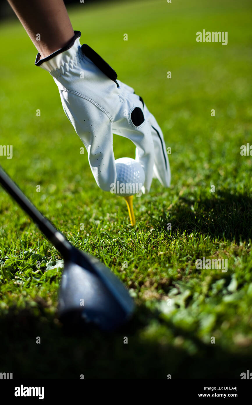 Playing golf, ball on tee Stock Photo - Alamy