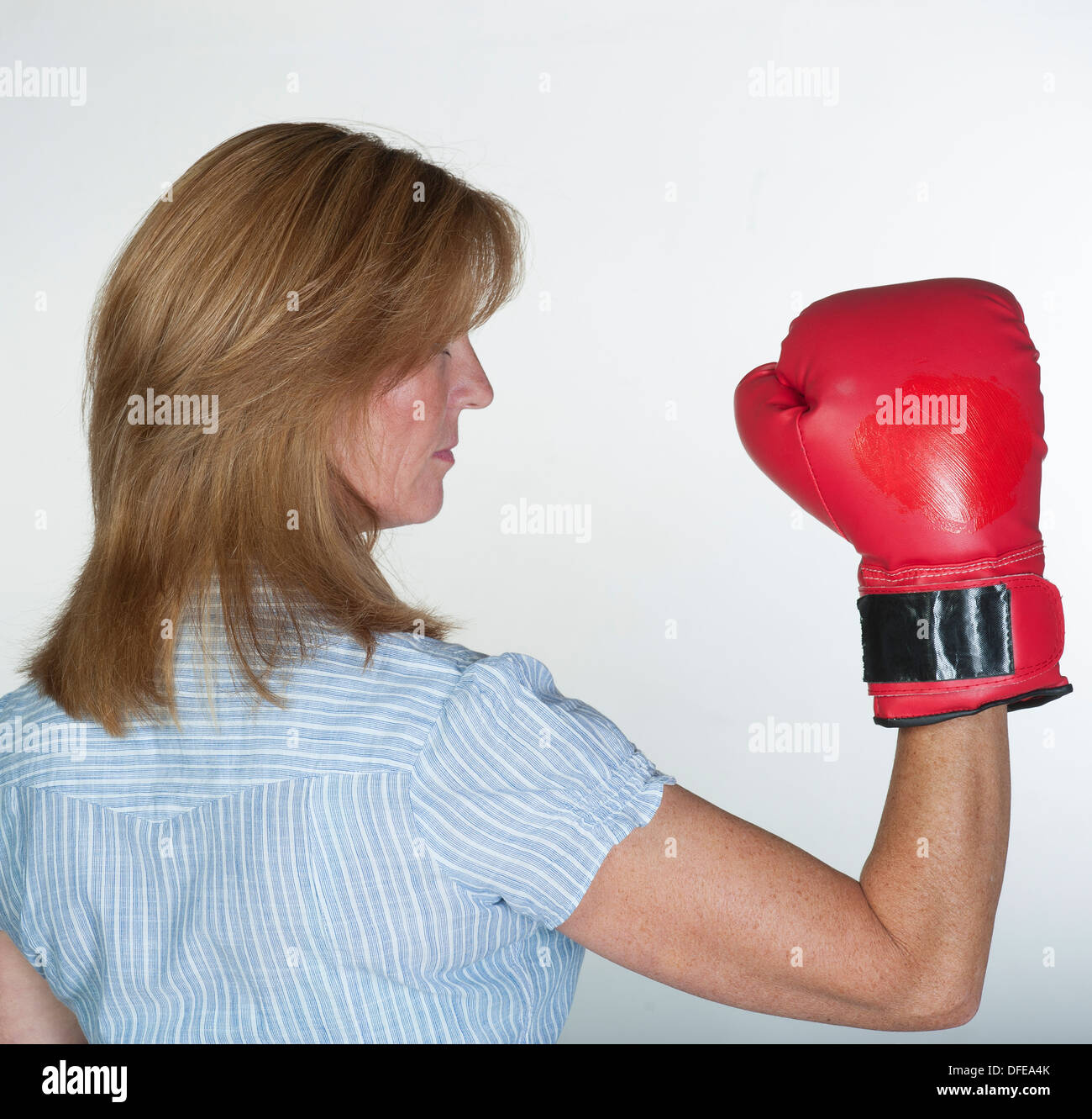Woman wearing a red boxing glove in fighting mood Stock Photo - Alamy