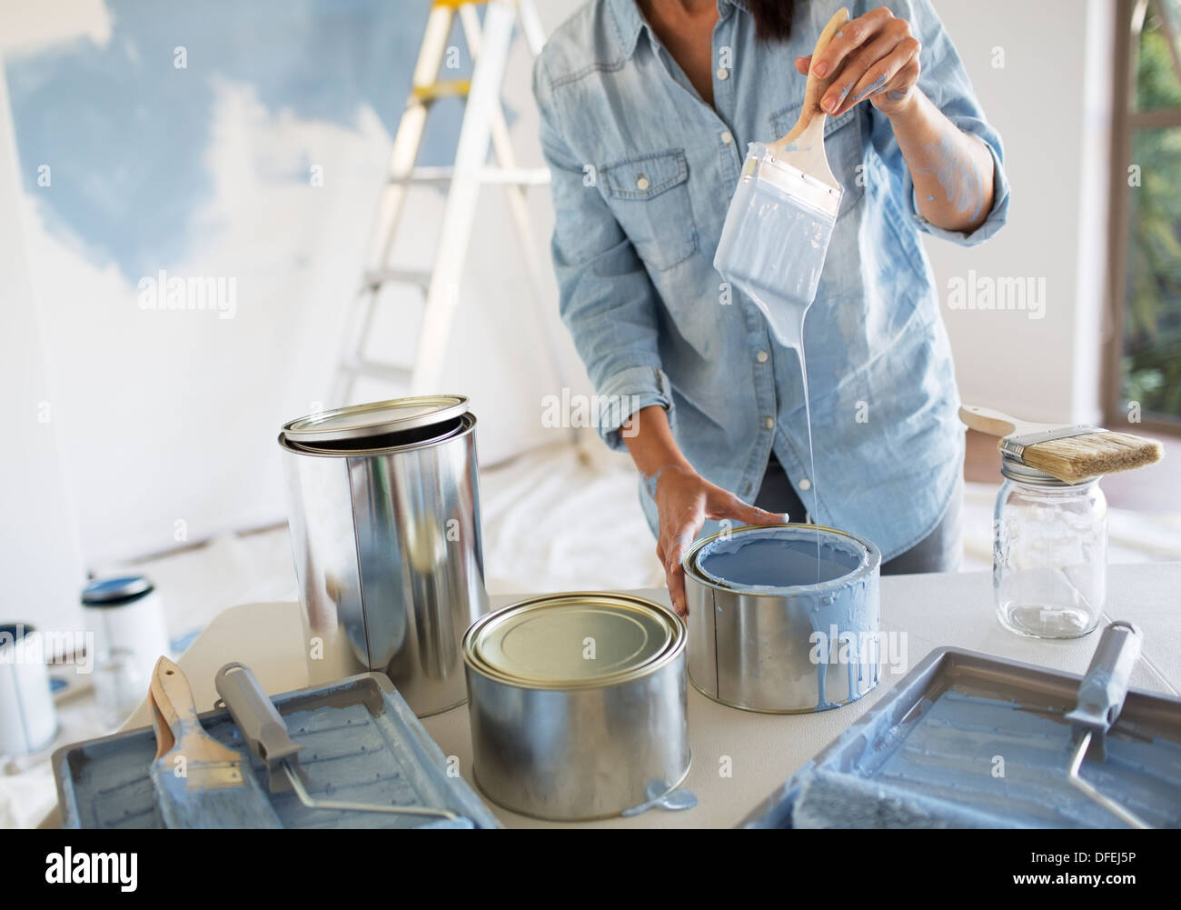 Woman holding paintbrush with blue paint Stock Photo - Alamy