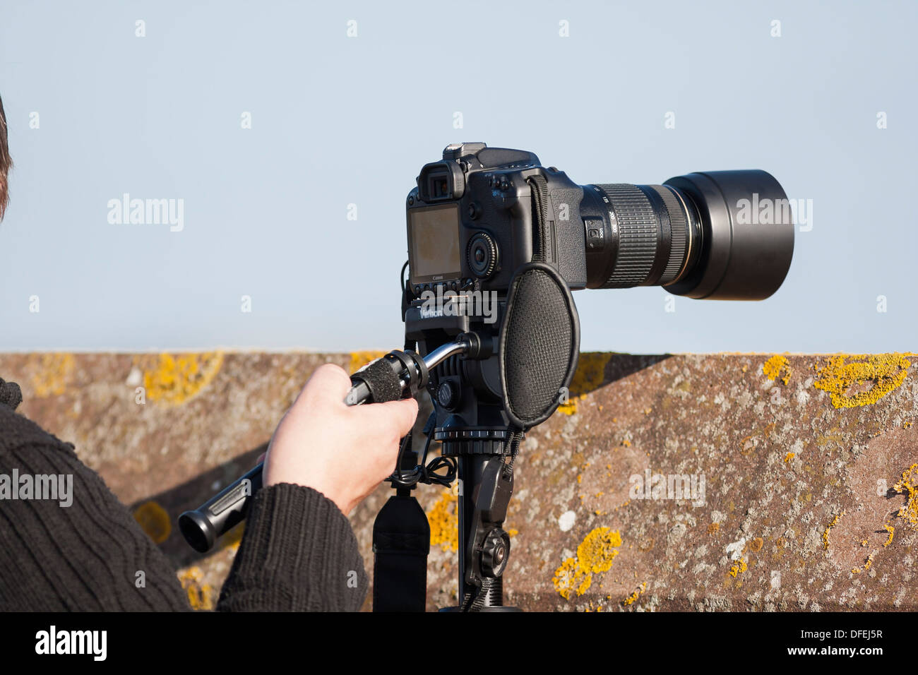 photographer with slr camera shooting over wall Stock Photo - Alamy