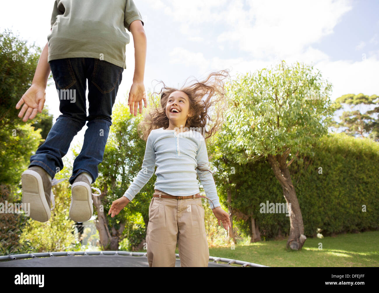 Children jumping on trampoline in backyard Stock Photo - Alamy