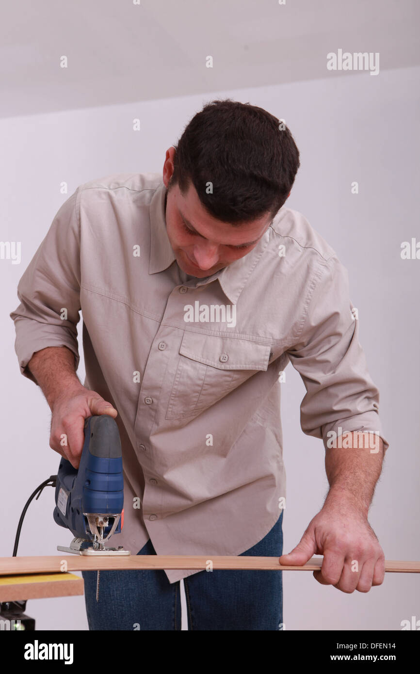 Man cutting wood with a saw Stock Photo - Alamy