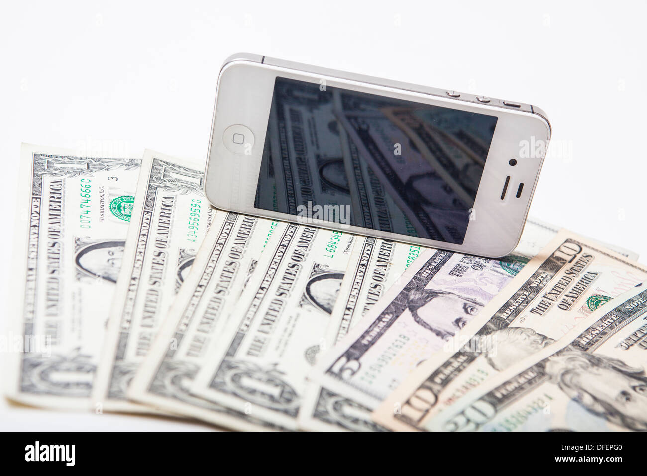 Cash for your iphone. U.S. currency and a used iphone on a white ...