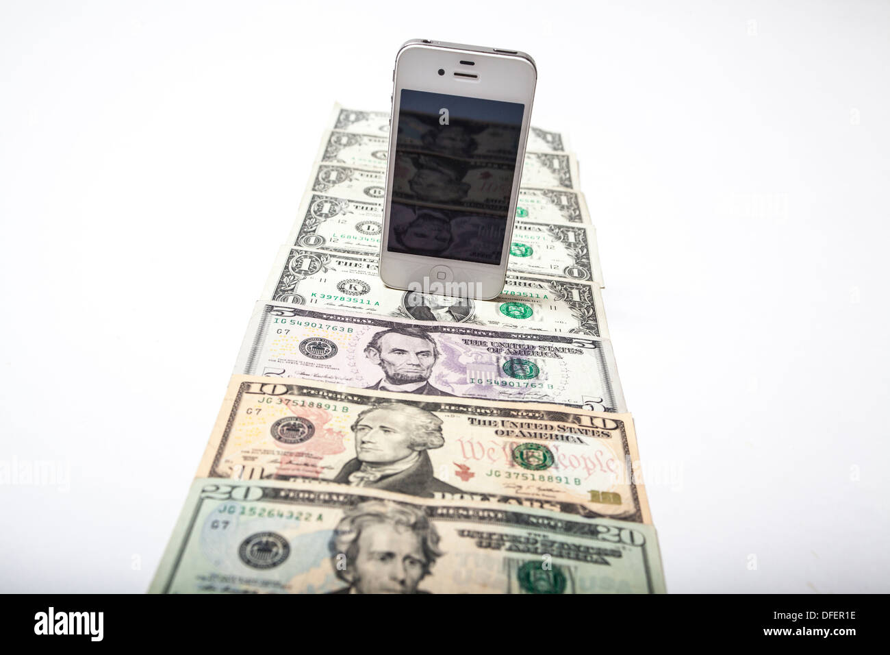 Cash for your iphone. U.S. currency and a used iphone on a white ...