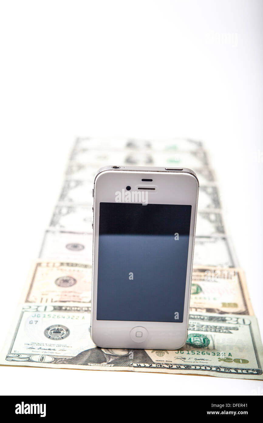 Cash for your iphone. U.S. currency and a used iphone on a white ...
