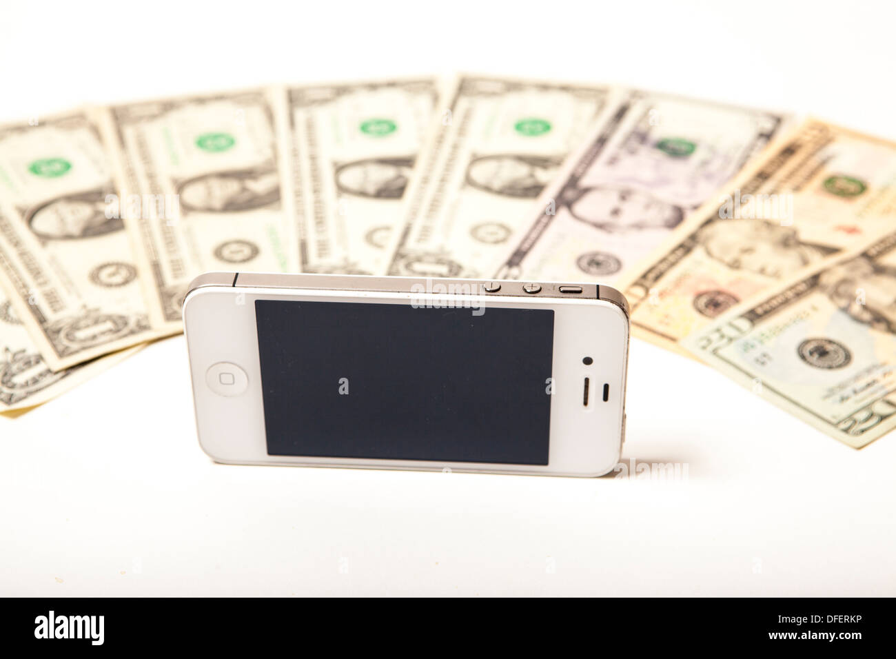 Cash for your iphone. U.S. currency and a used iphone on a white ...