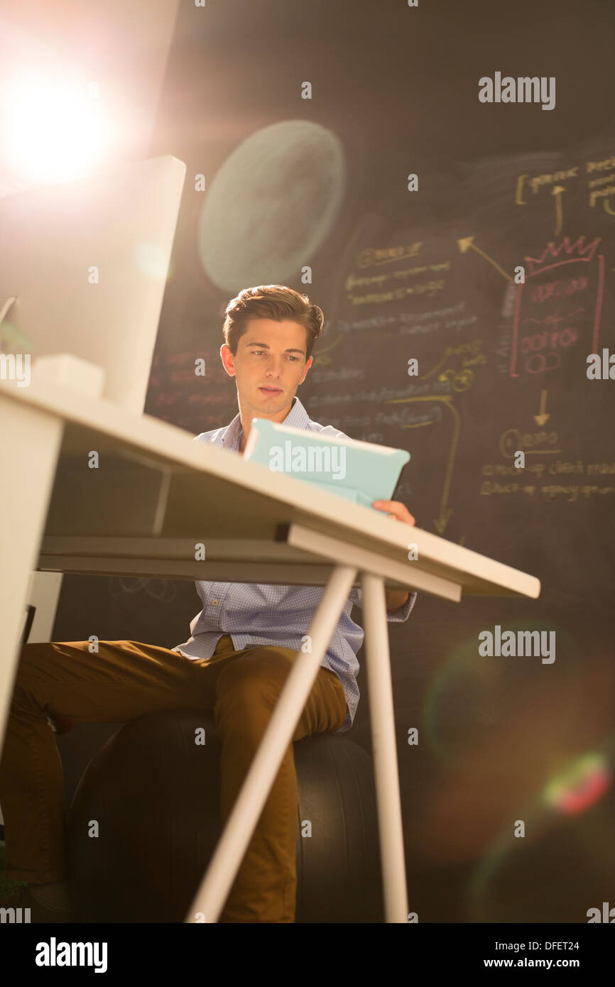 Young man is concentrating while working at his desk hi-res stock ...