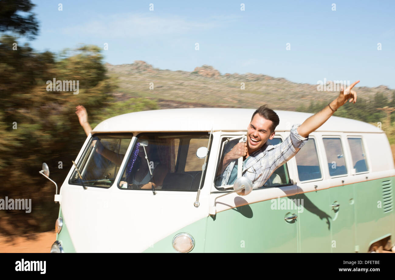 Man leaning head out camper van window on rural road Stock Photo - Alamy