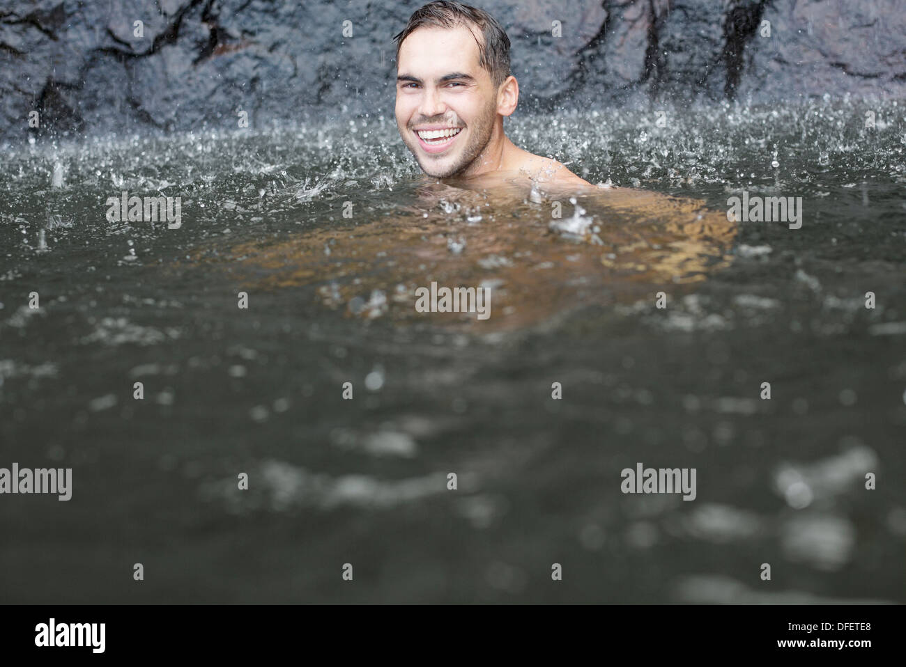 Rain falling on man in lake Stock Photo - Alamy