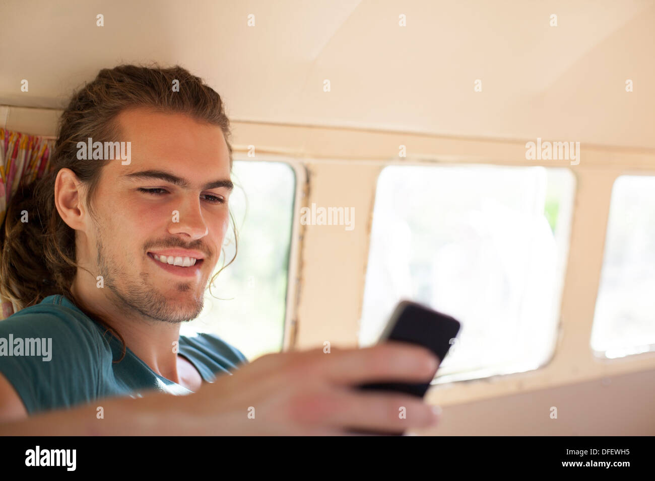 Man using cell phone in camper van Stock Photo - Alamy