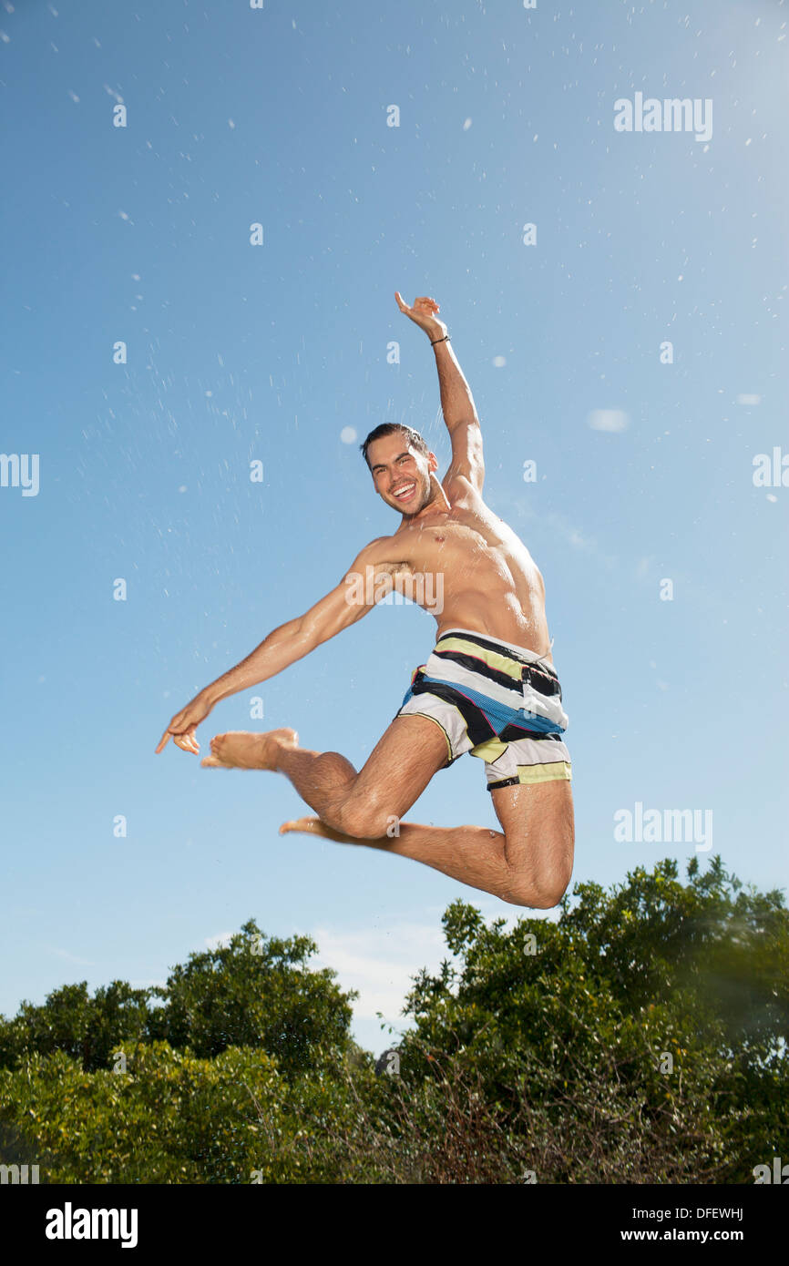 Man in swim trunks jumping Stock Photo - Alamy
