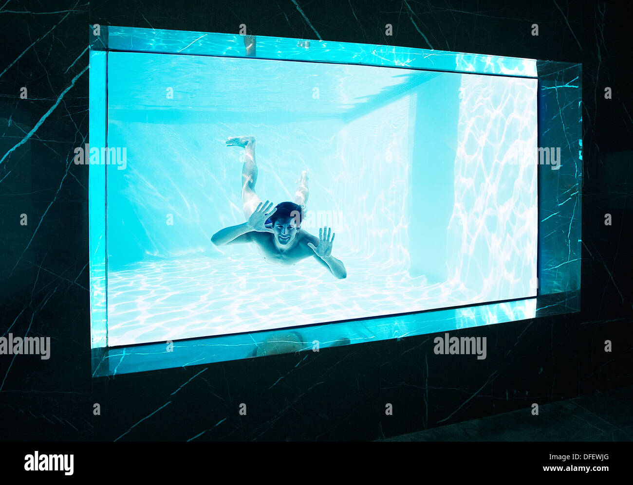 Man looking through window underwater in swimming pool Stock Photo - Alamy