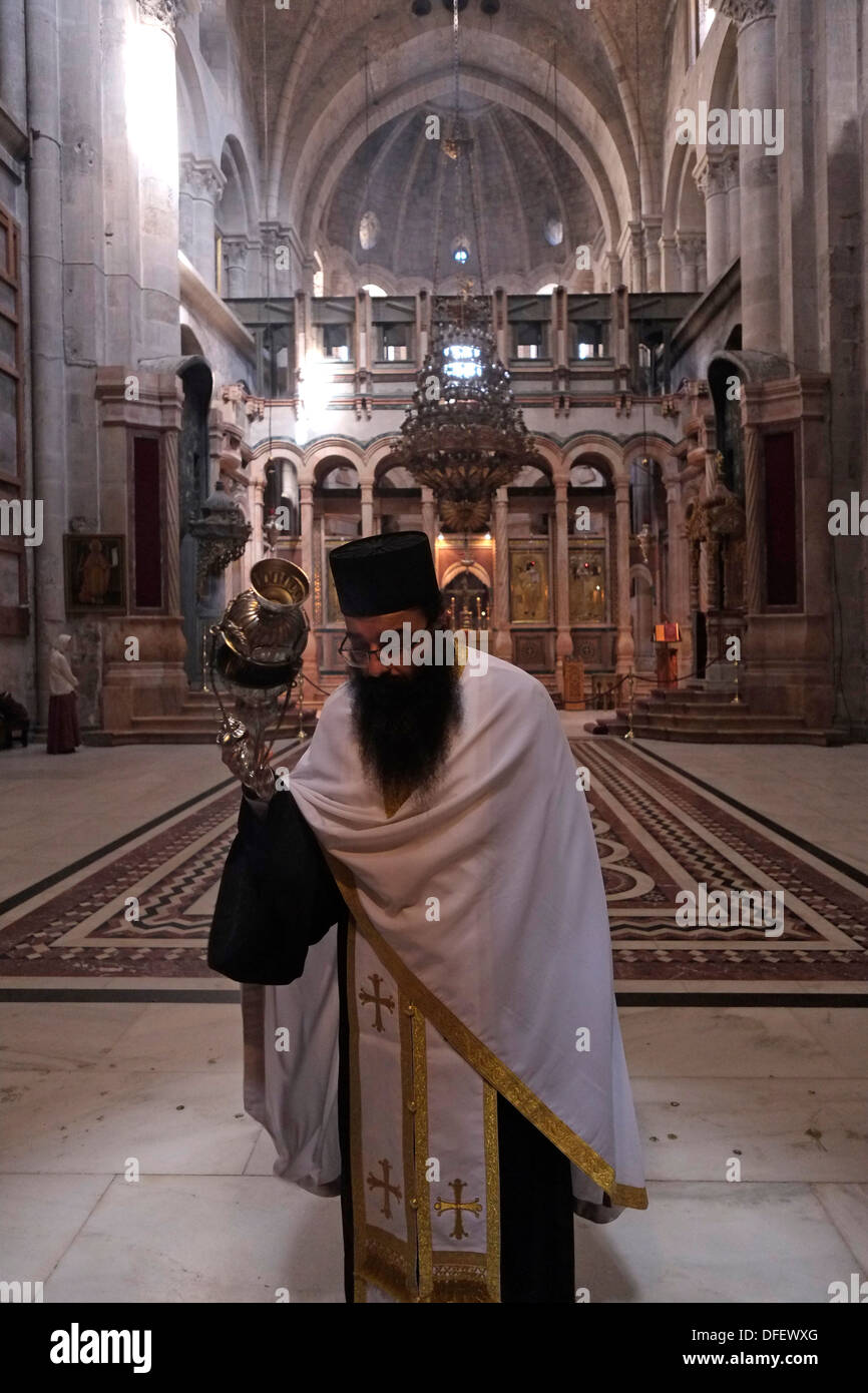 A Greek Orthodox priest censing with thurible inside the Katholikon or ...