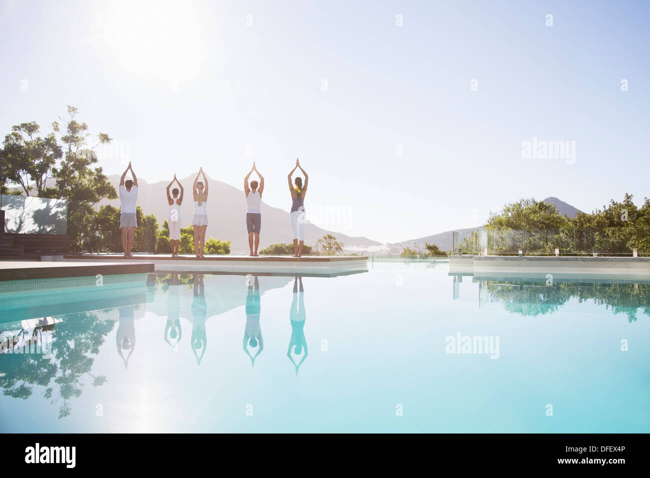 People practicing yoga at poolside Stock Photo - Alamy