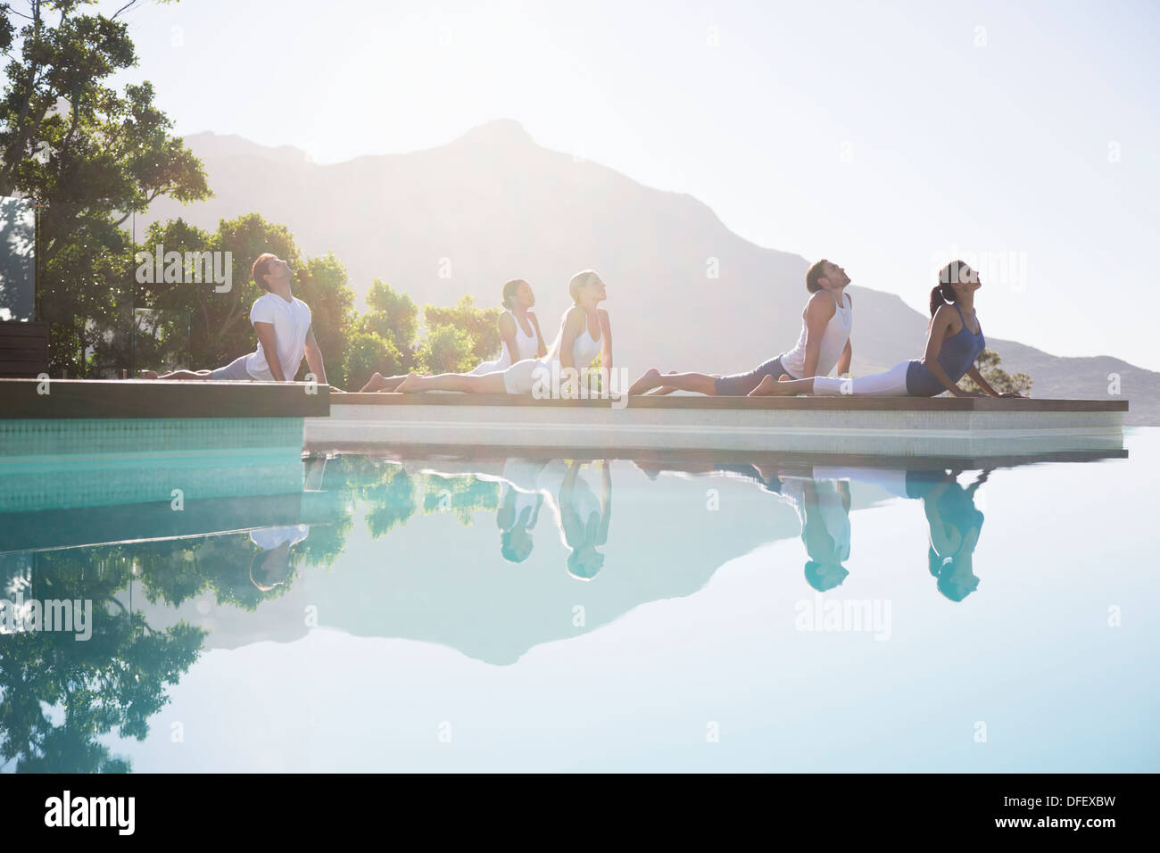 People practicing yoga at poolside Stock Photo - Alamy