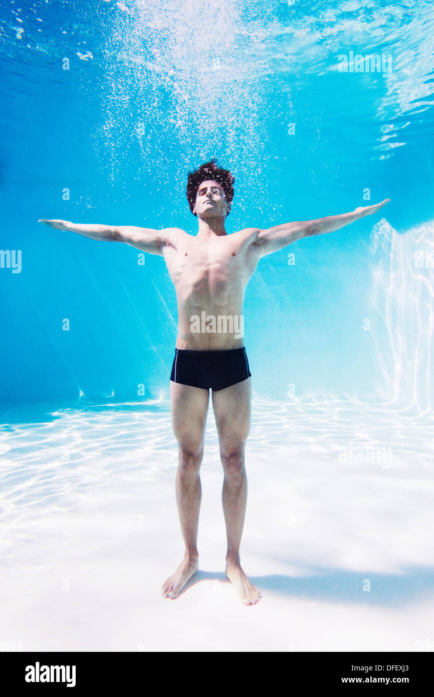Man standing underwater in swimming pool with arms outstretched Stock ... Man standing underwater in swimming pool with arms outstretched Stock ...