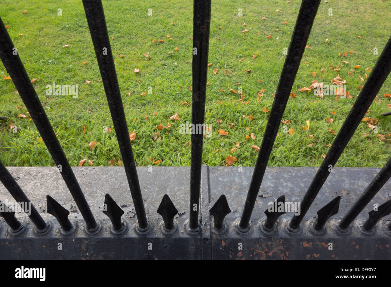 Metal fence railings with spikes with a lawn beyond Stock Photo - Alamy